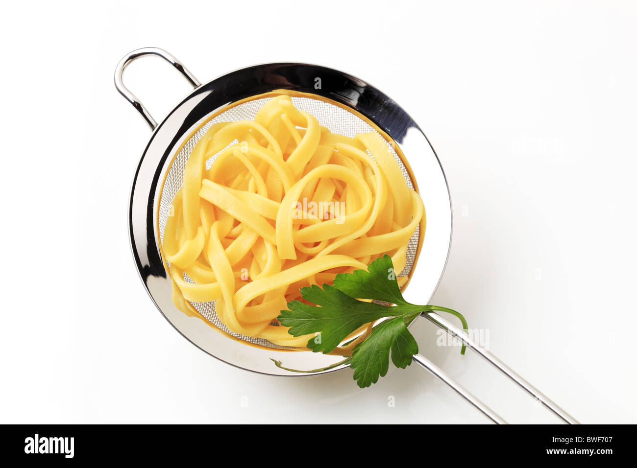 Cooked ribbon pasta in a metal sieve Stock Photo - Alamy