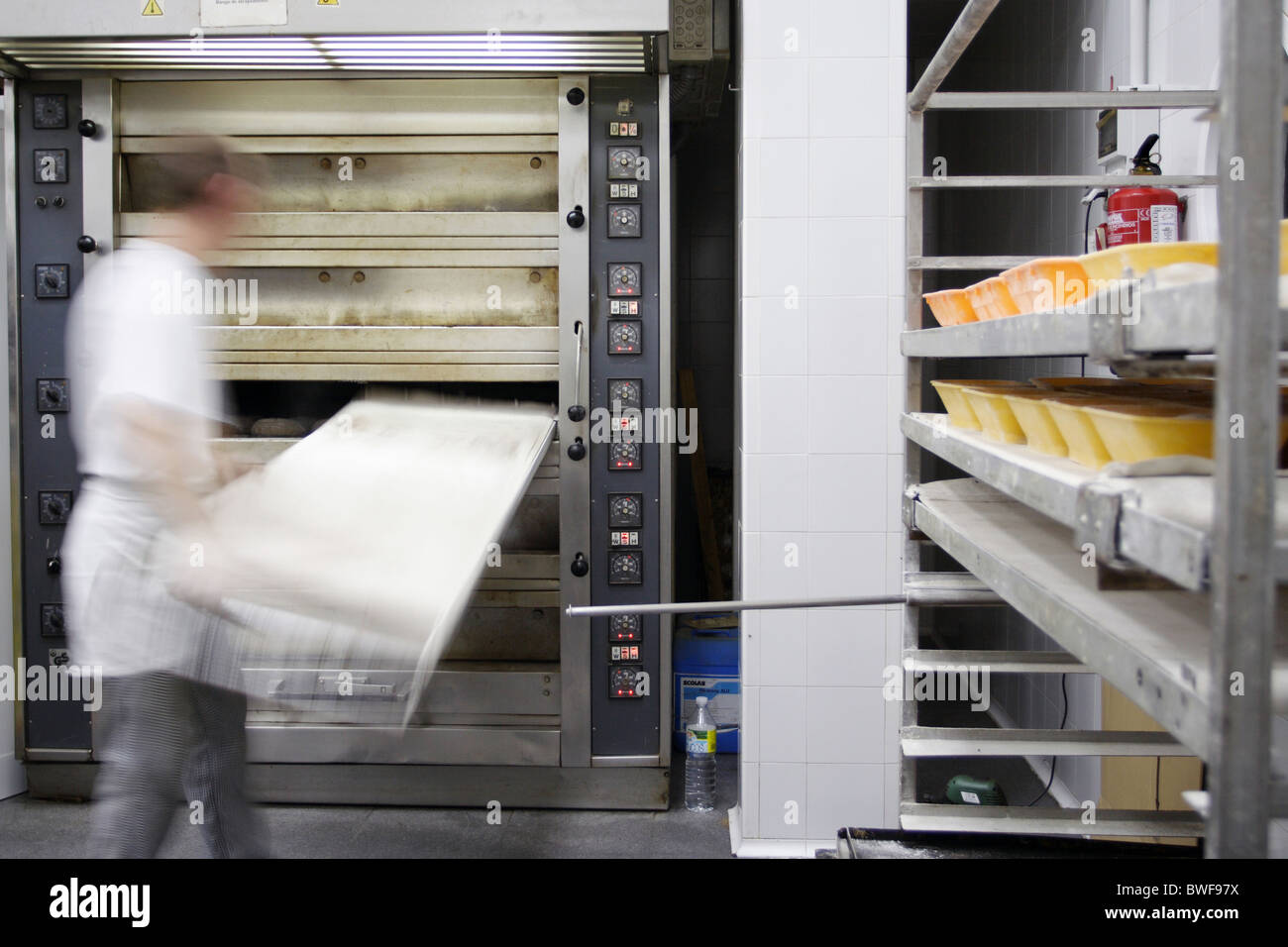 A baker loading loaves of bread into a deck oven, Conil de la Frontera ...