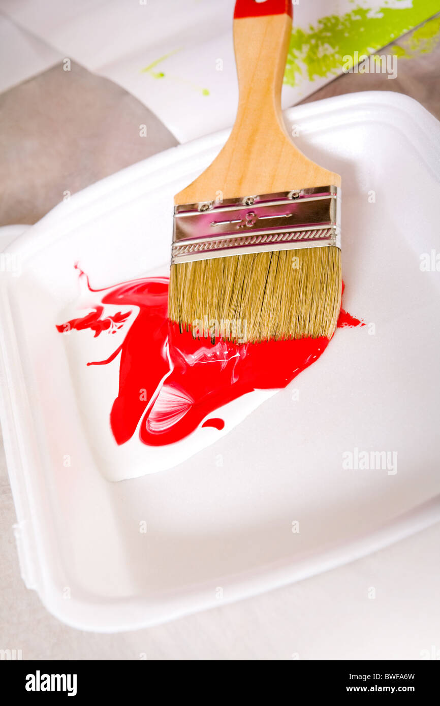 Image of paintbrush in tray with white and red colors Stock Photo - Alamy