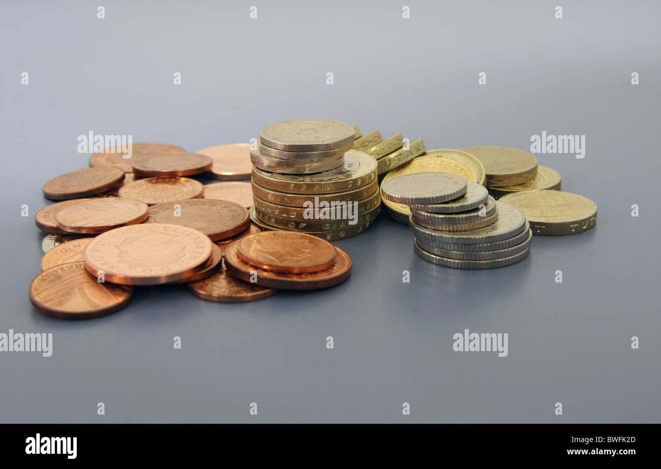 A variety of sterling coins in stacks and in a pile around the stacks ...