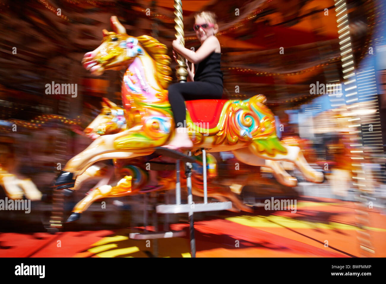 Young girl riding the Carousel funfair ride at Cardiff bay, south Wales ...