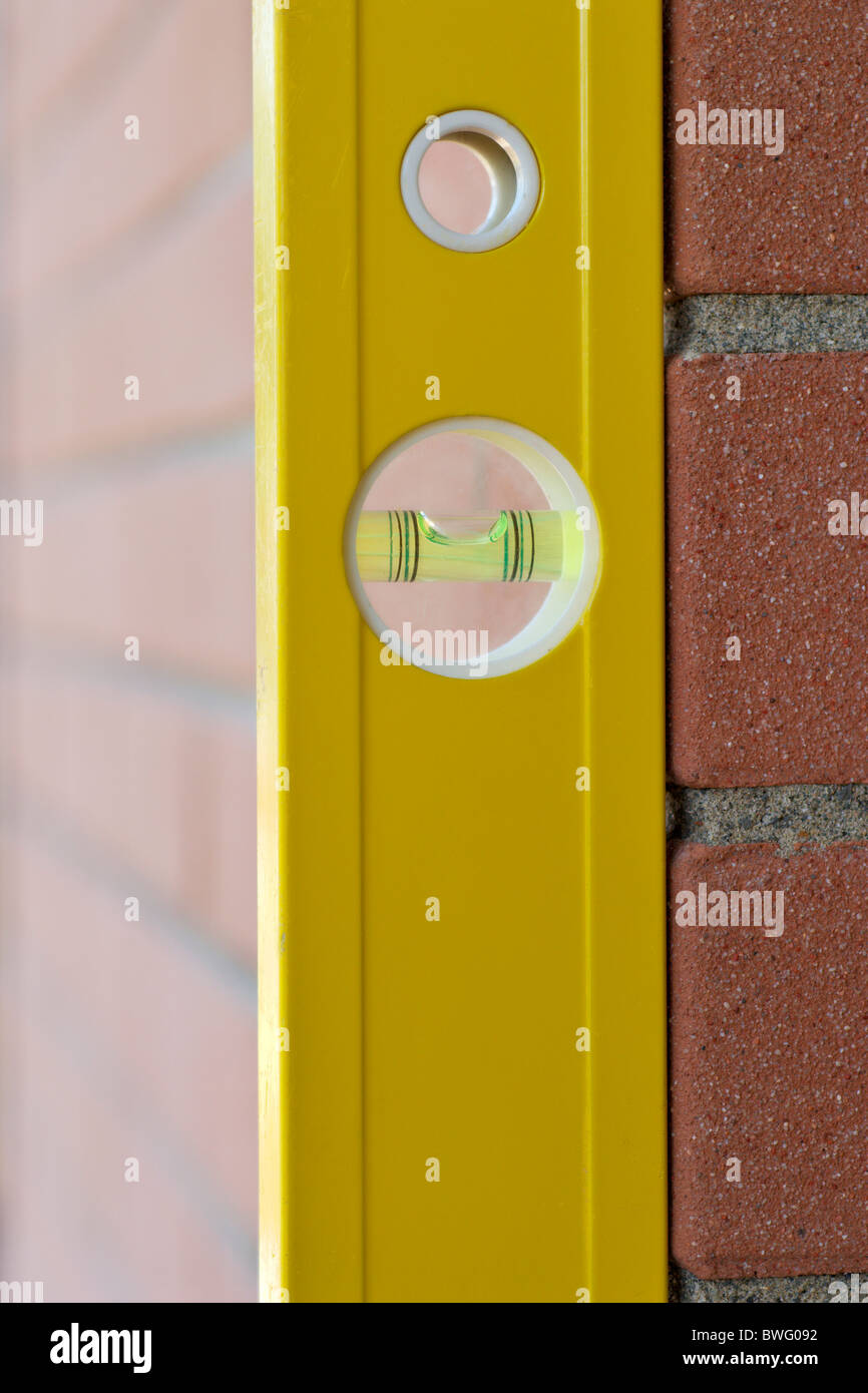 Spirit Level against vertical brick wall Stock Photo - Alamy