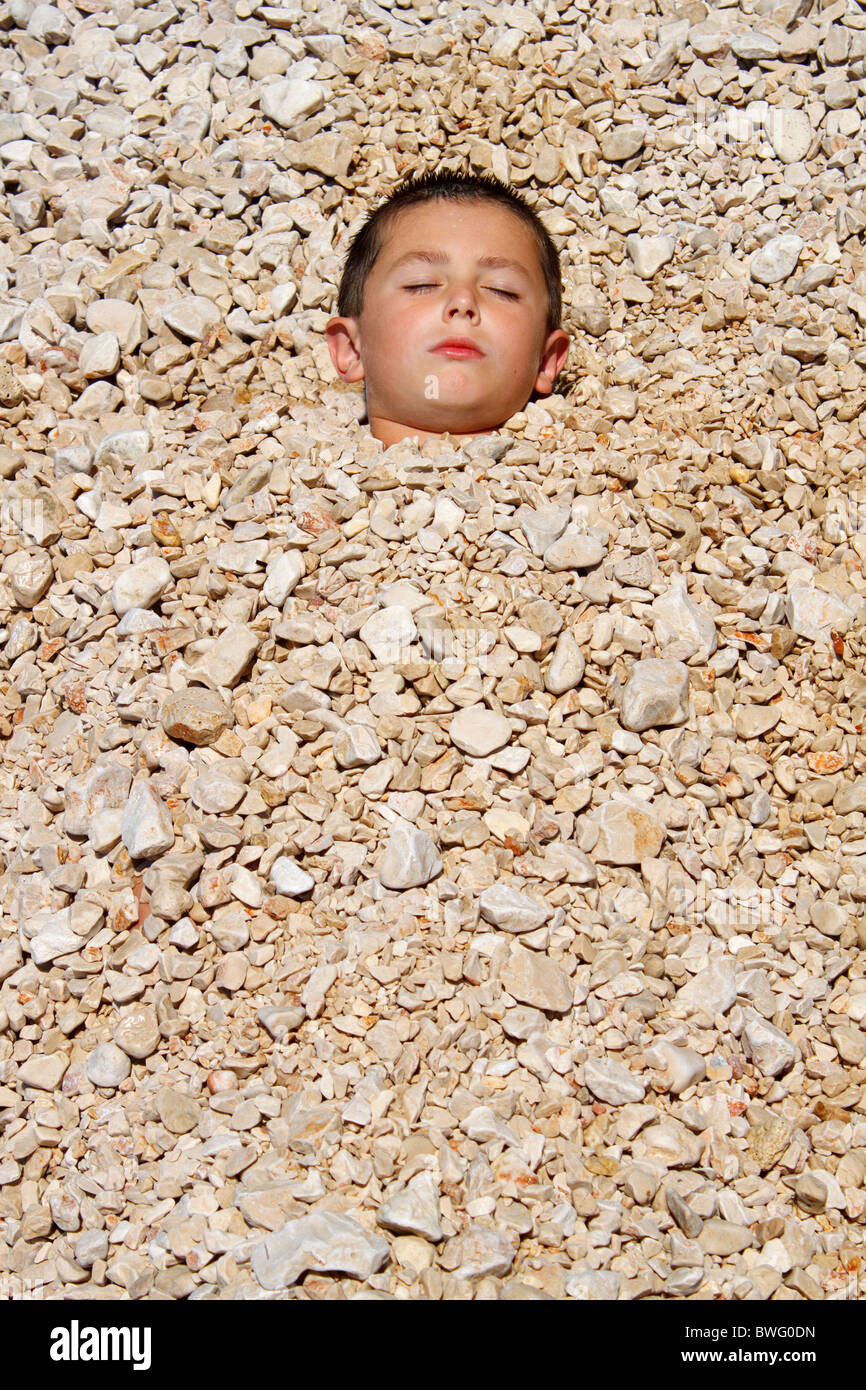 Boy buried in sand on hi-res stock photography and images - Alamy