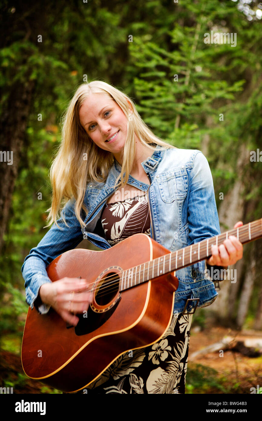 A happy pretty woman with a guitar Stock Photo - Alamy