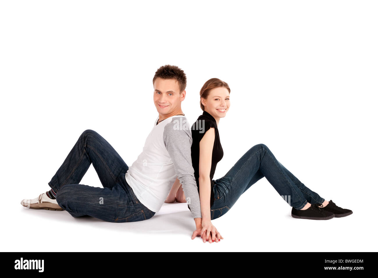 Young casual happy couple sitting back to back on white isolated ...