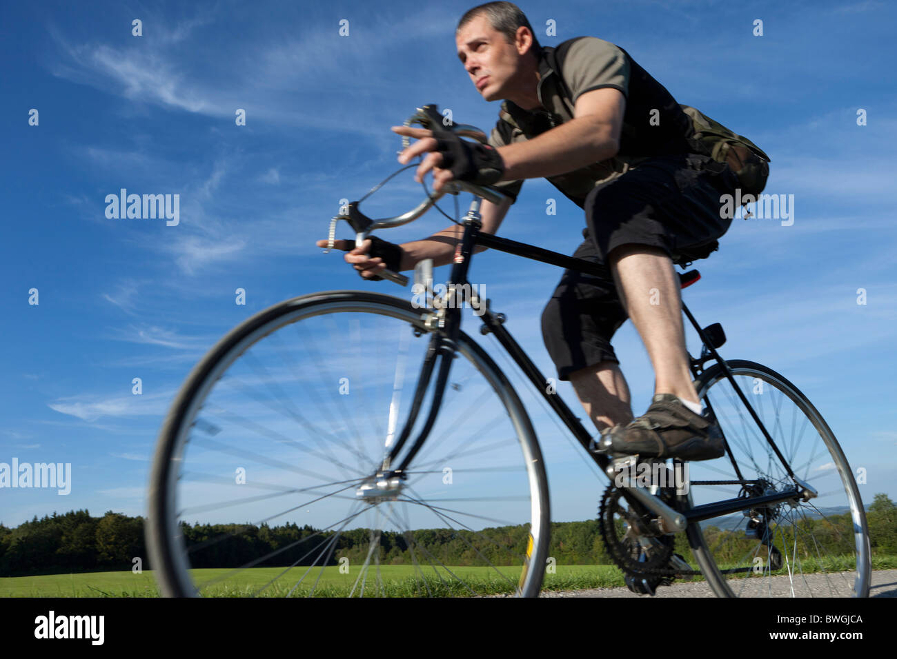Man cycling fast with road bike Stock Photo - Alamy