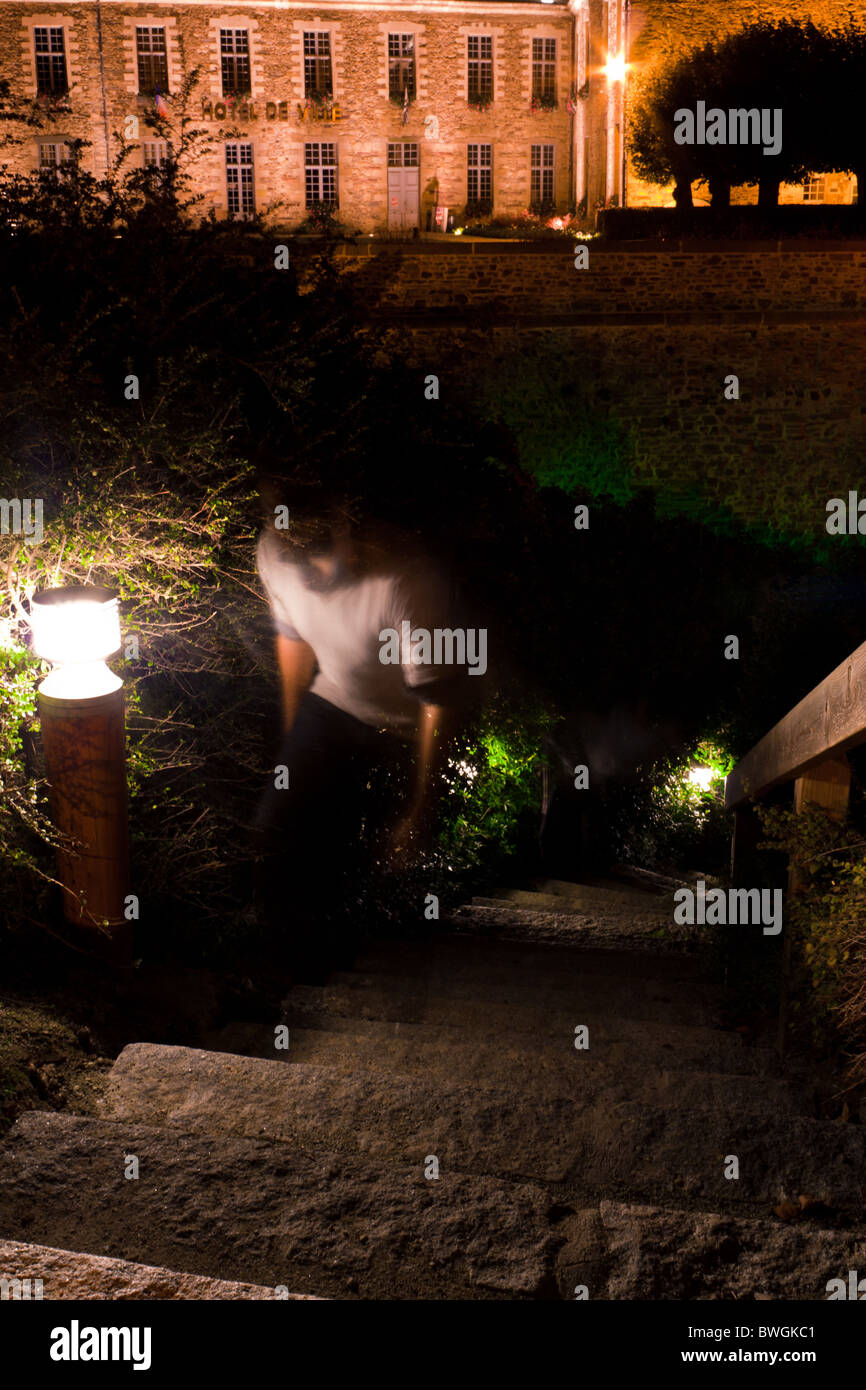 A man walking up stairs at night Stock Photo - Alamy