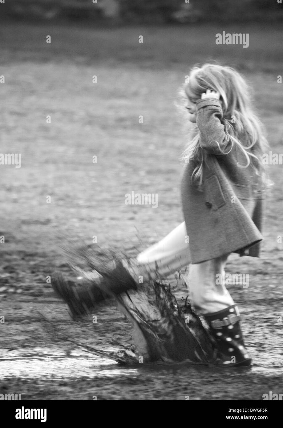 Girl splashing in muddy puddle Stock Photo - Alamy