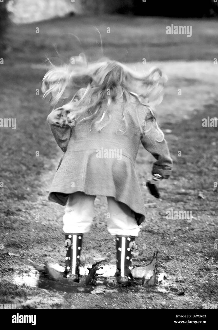 Girl splashing in puddle Stock Photo - Alamy