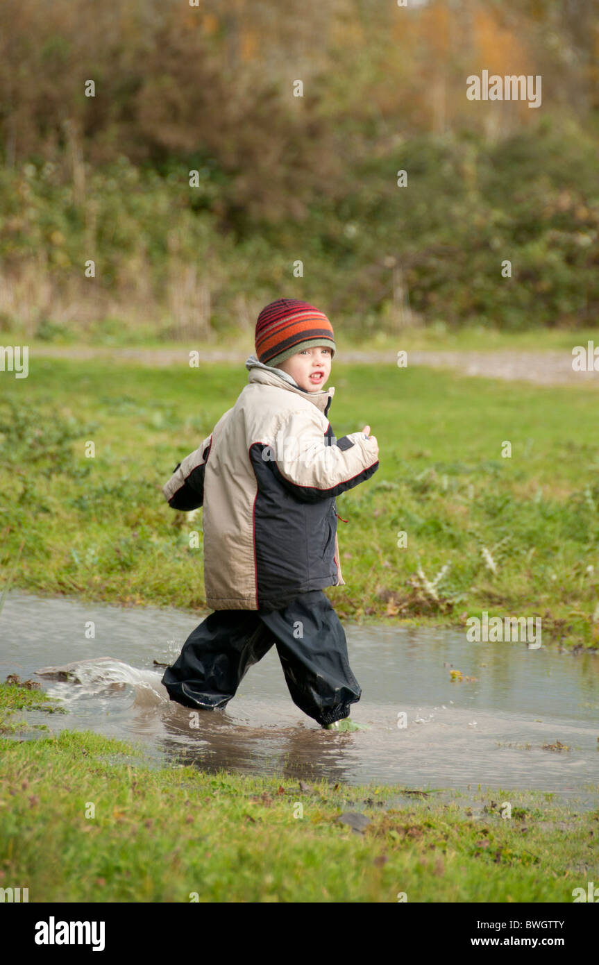 Boy running through puddles hi-res stock photography and images - Alamy