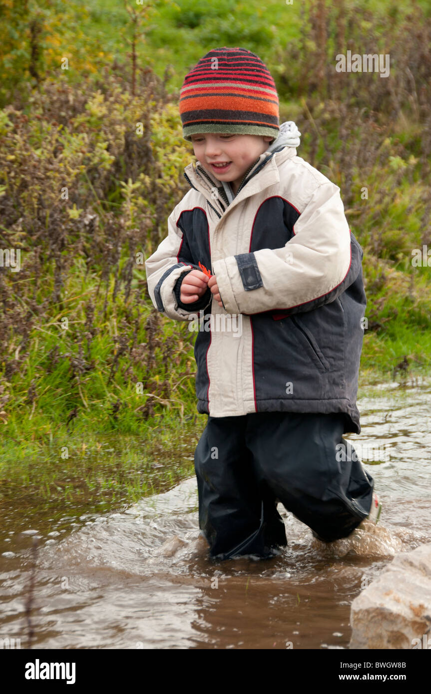 A boy playing in a puddle at Conwy RSPB reserve Stock Photo - Alamy
