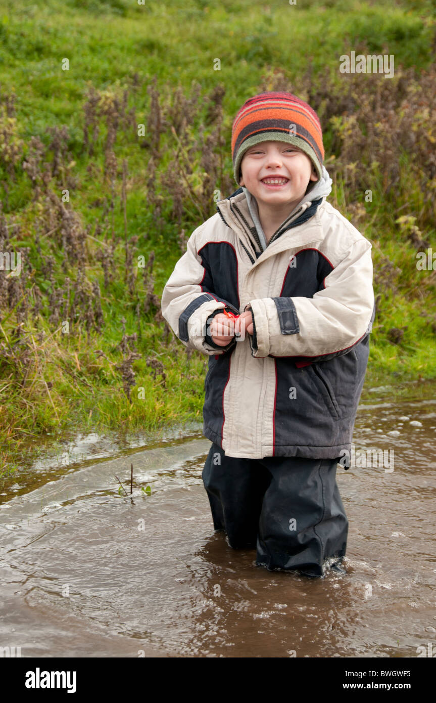 A boy playing in a puddle at Conwy RSPB reserve Stock Photo - Alamy