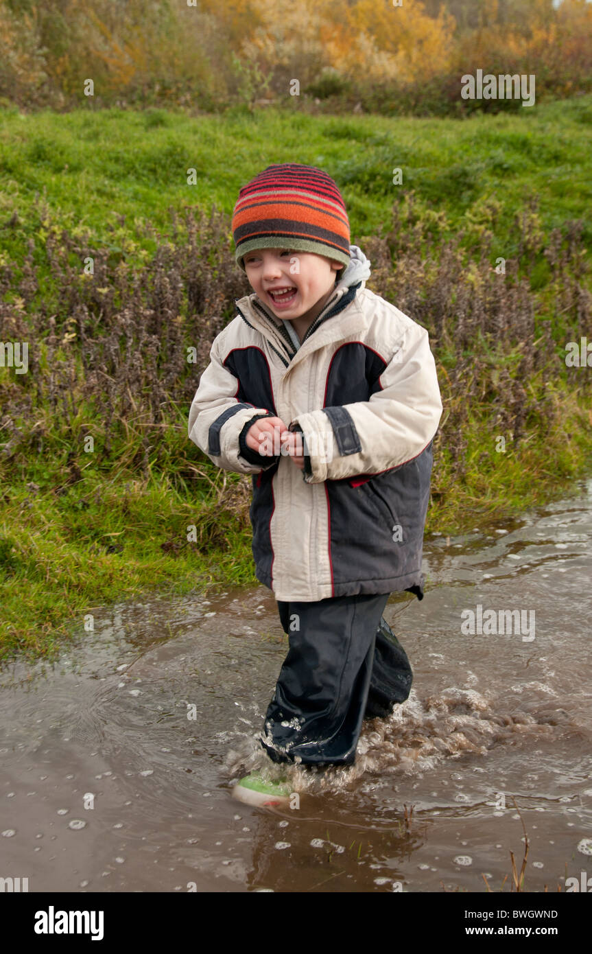 A boy playing in a puddle at Conwy RSPB reserve Stock Photo - Alamy