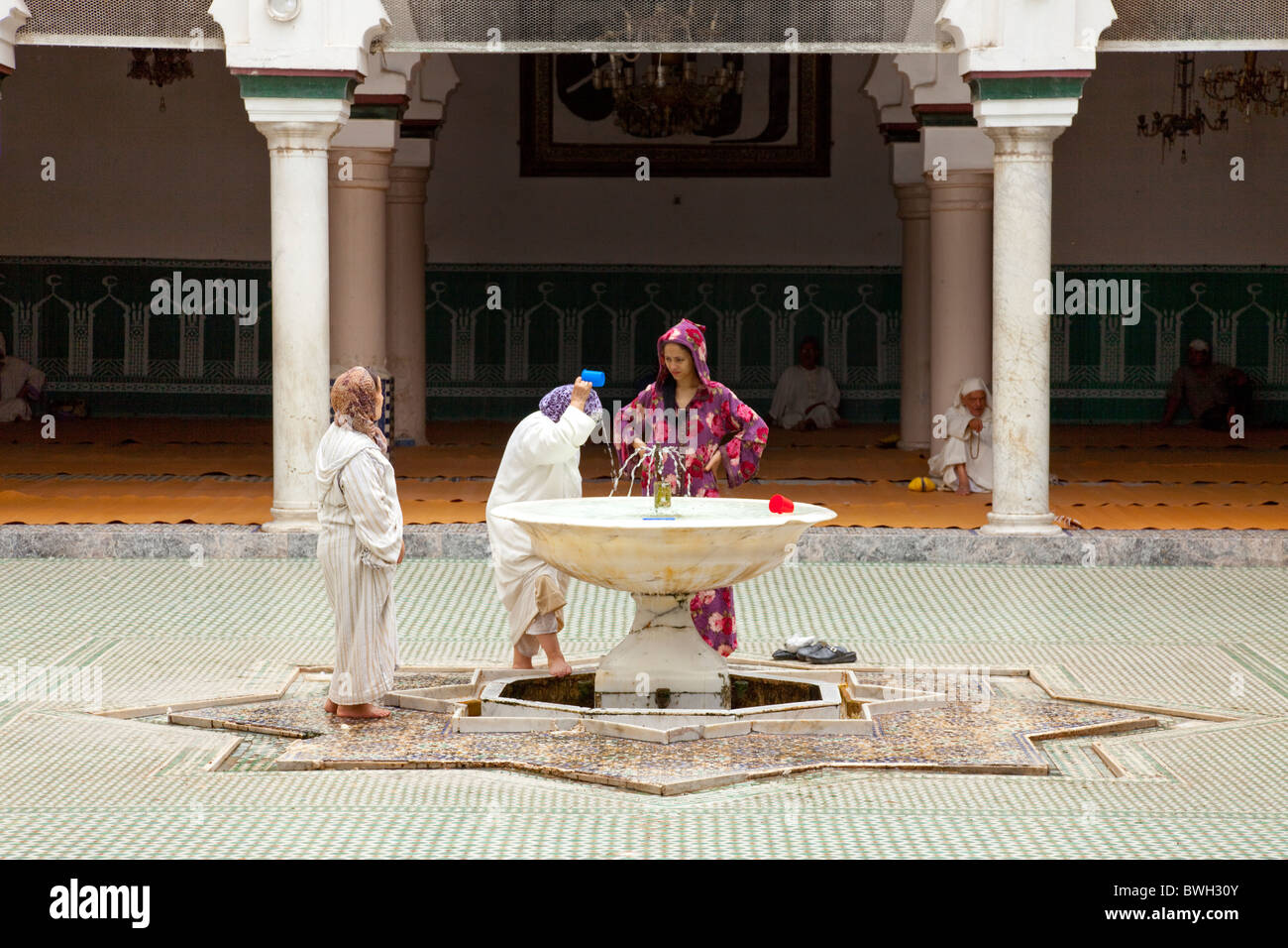 Female Islamic worshipers cleanse themselves at an ablution fountain at ...