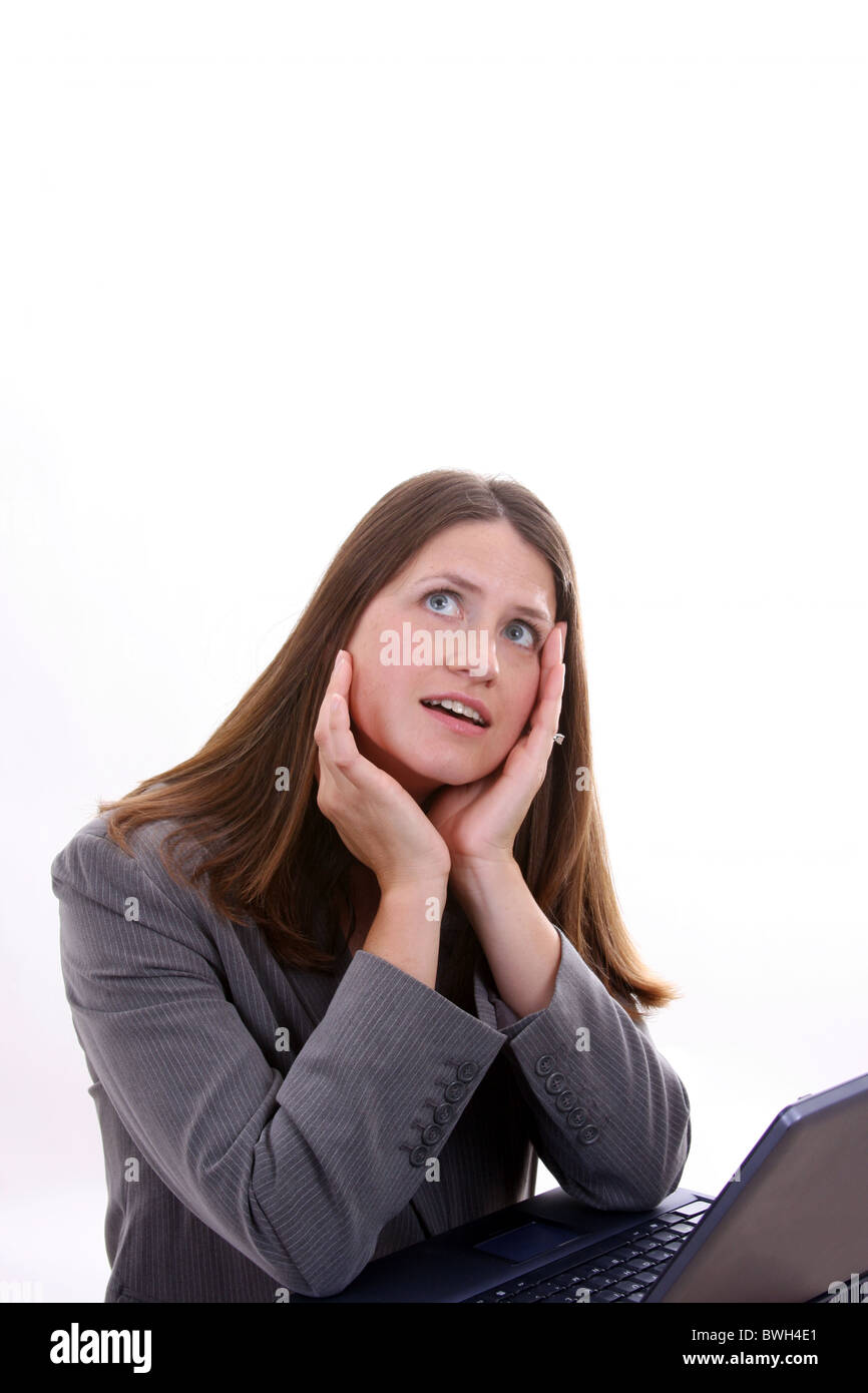 A young business woman looking up thinking using a laptop Stock Photo ...