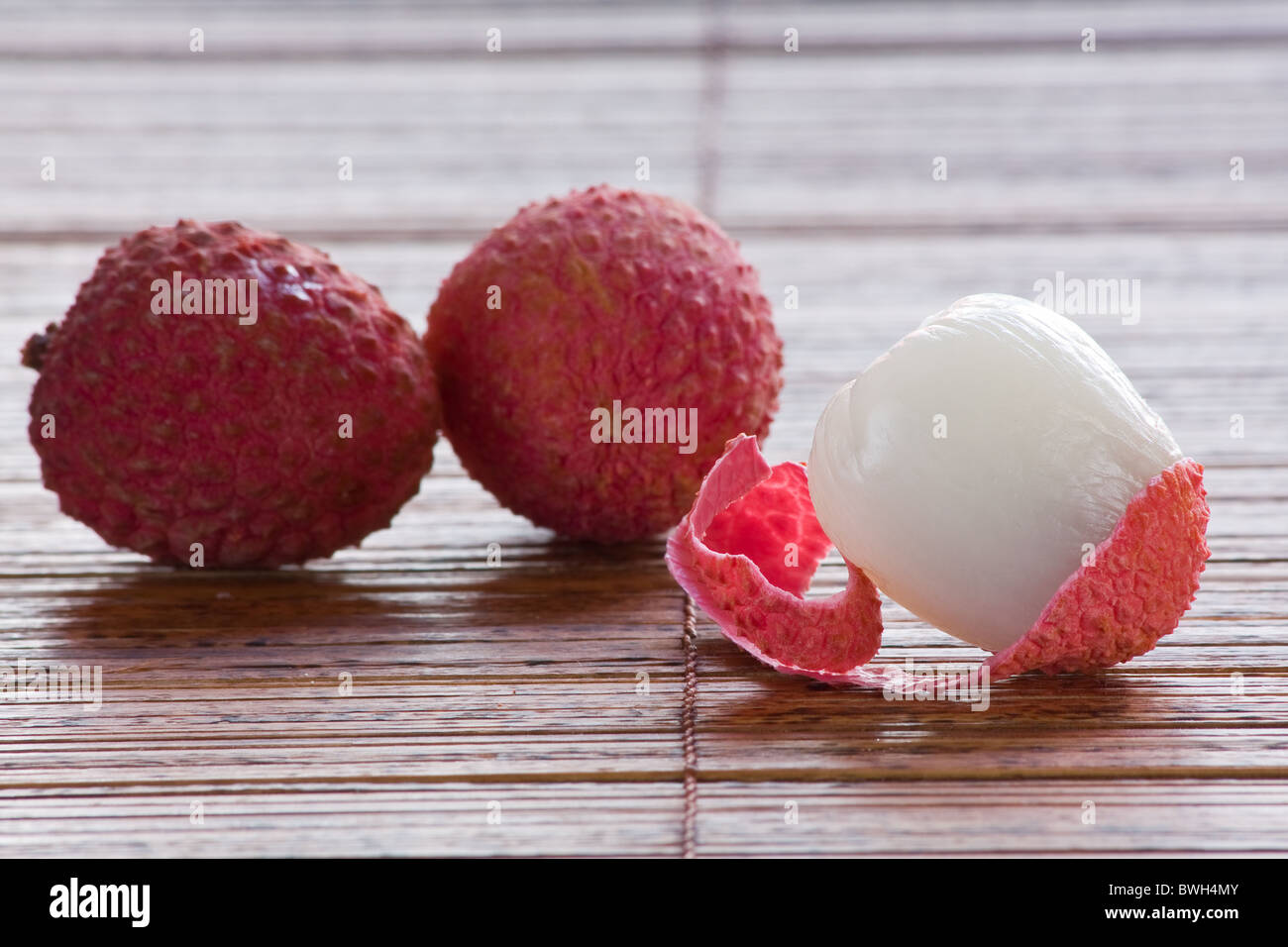 Whole and peeled lychee on bamboo mat Stock Photo - Alamy