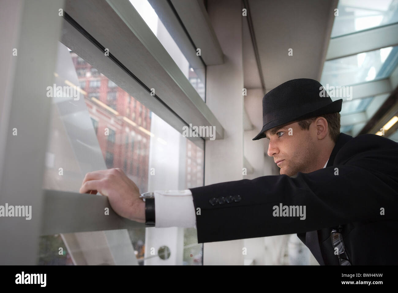 Man looking out window Stock Photo - Alamy