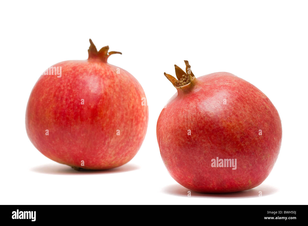 Two delicious fresh pomegranates over white background Stock Photo - Alamy