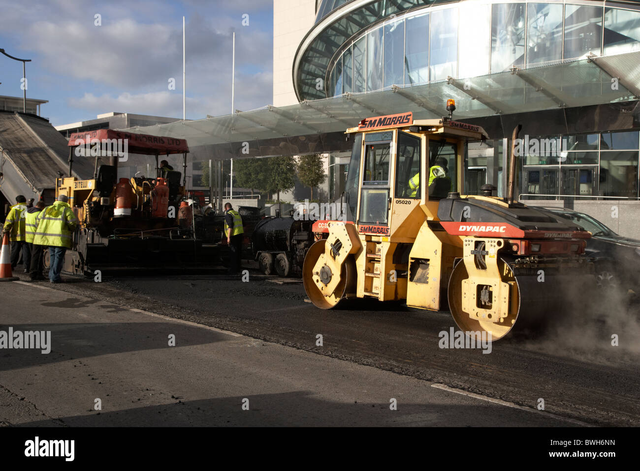 construction contract workers laying tarmac as part of infrastructure ...