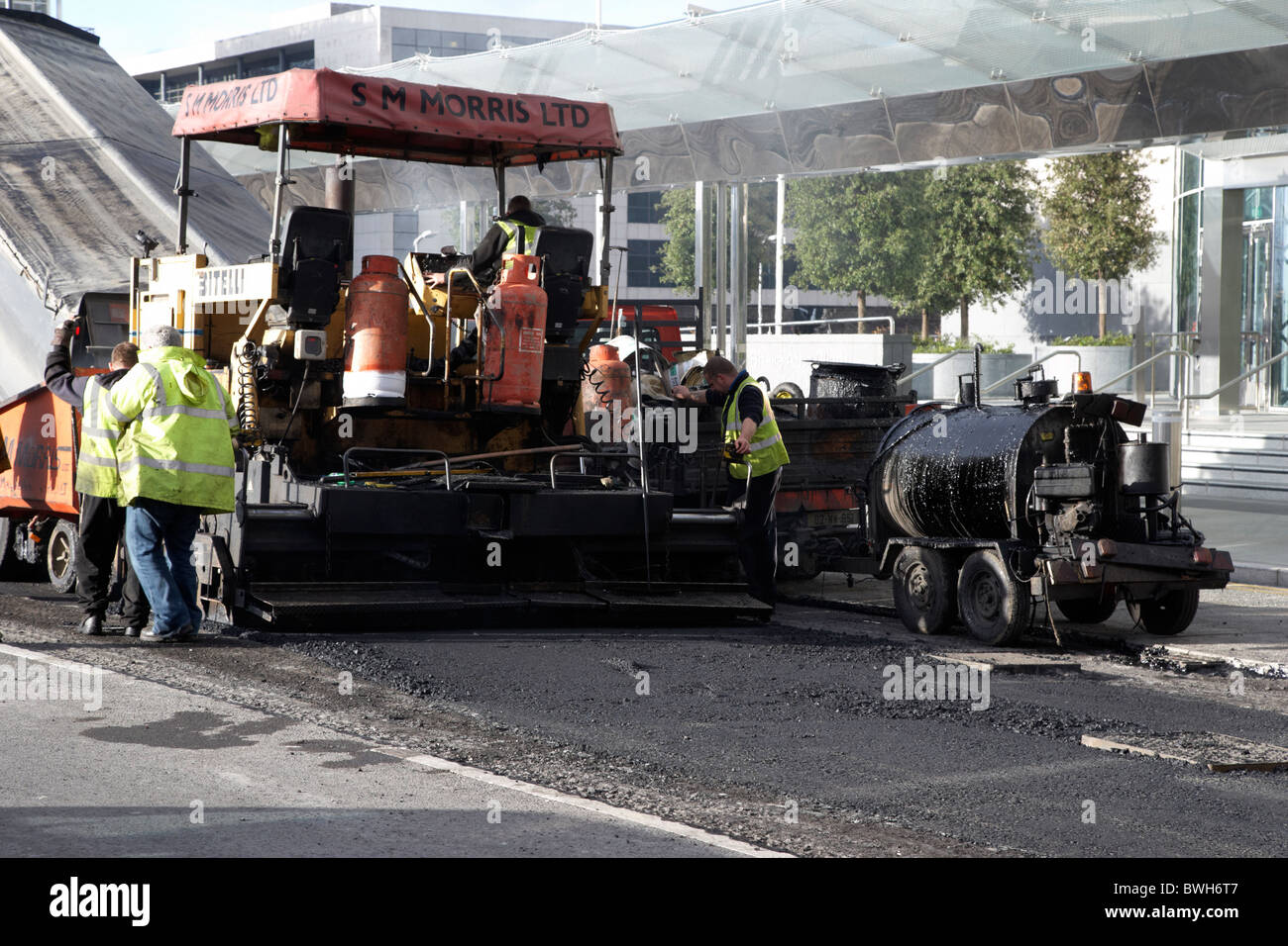 construction contract workers laying tarmac as part of infrastructure ...