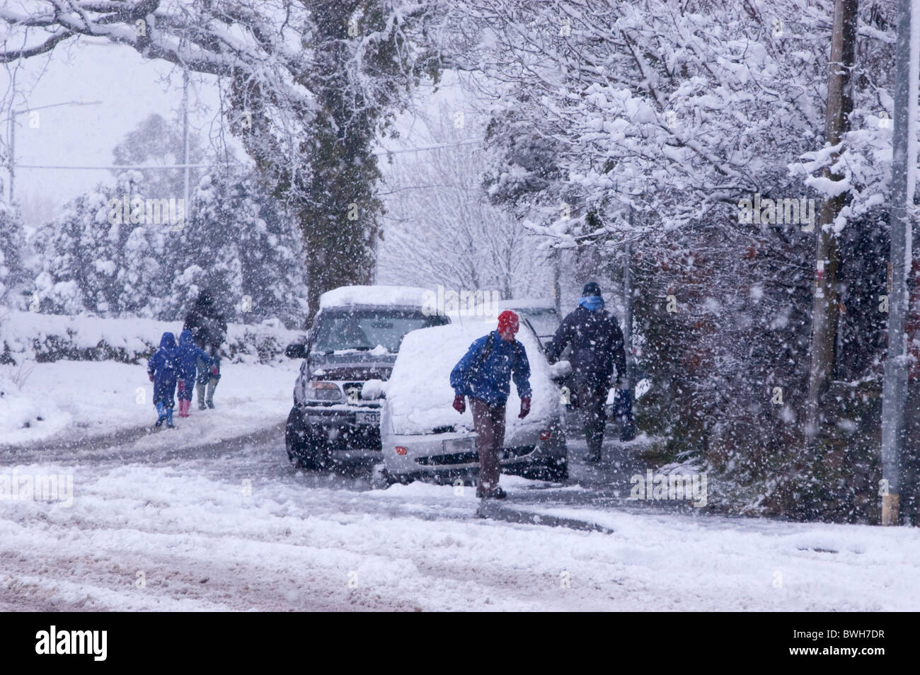 People walking along an urban road during heavy snowfall Stock Photo ...