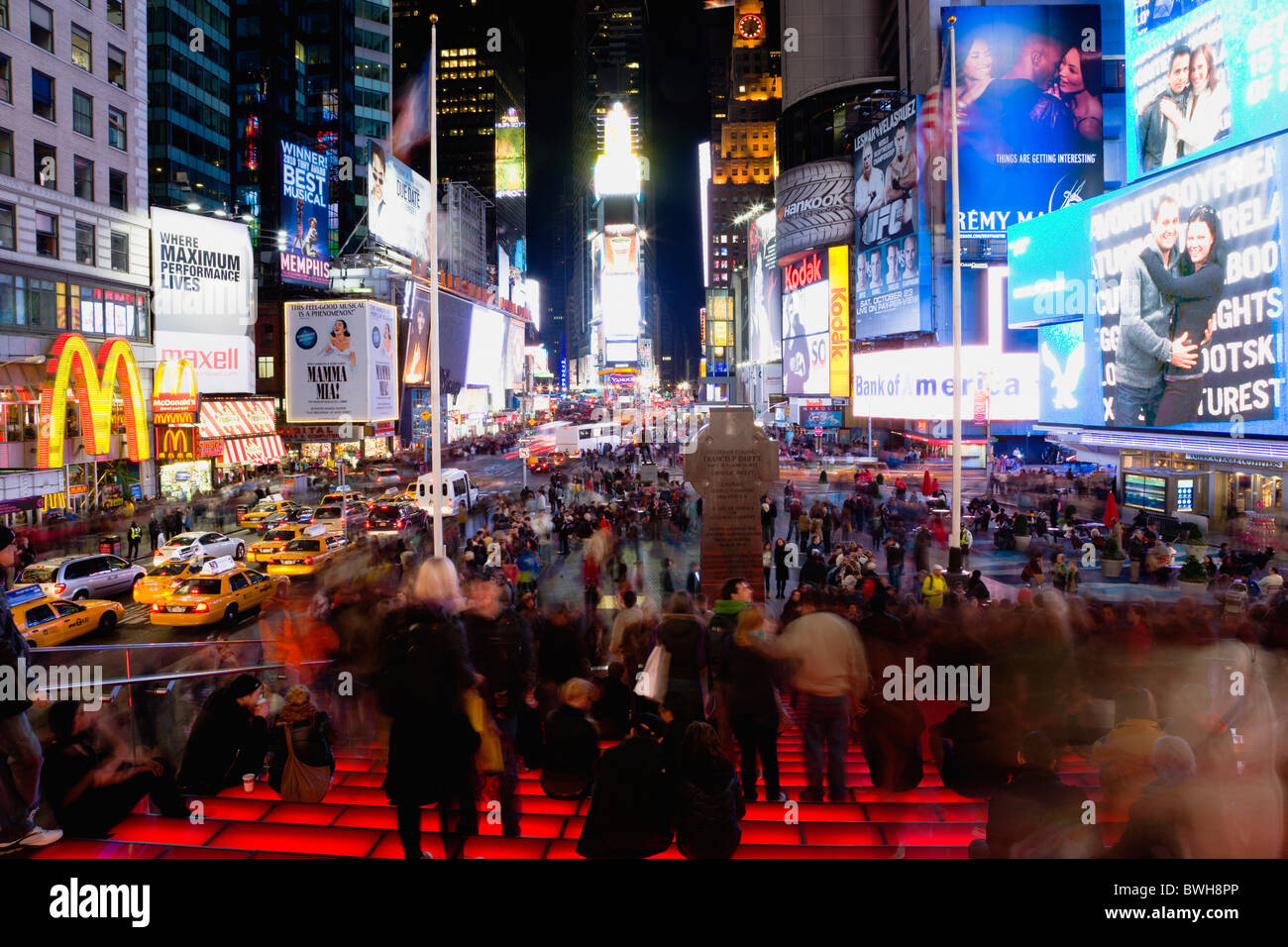 USA New York NYC Manhattan People sitting on lit red steps or walking ...