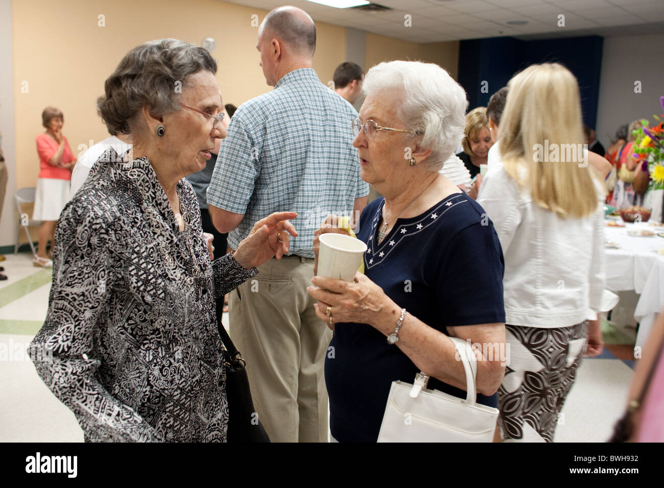 Elderly Anglo females chat during reception in fellowship hall at St ...