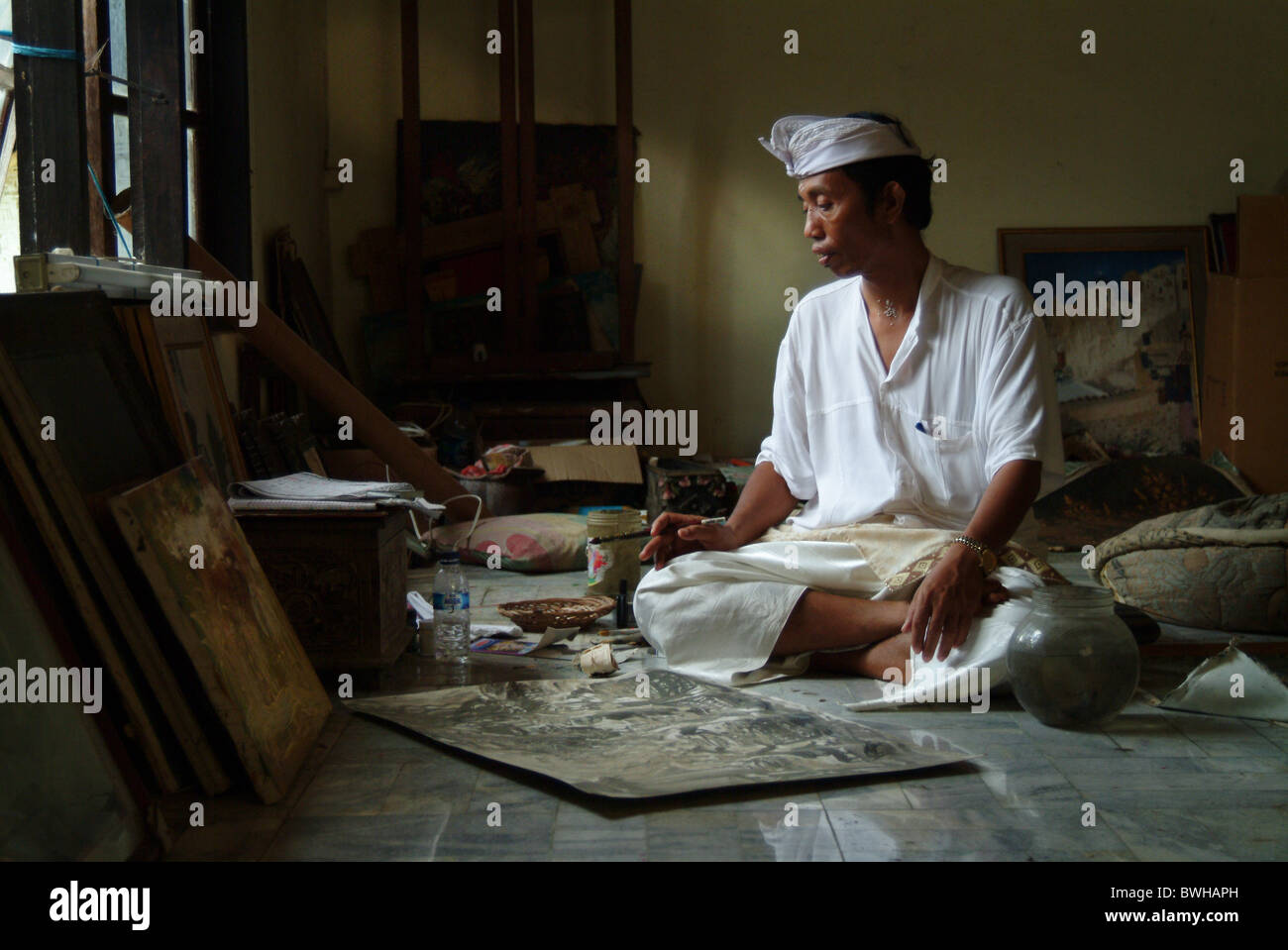 An artist paints in his studio in the village of Ubud, Bali, Indonesia ...