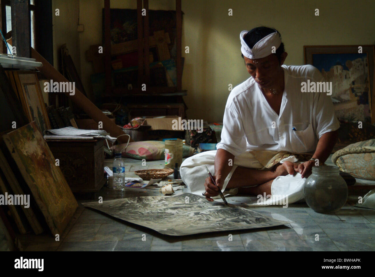 An artist paints in his studio in the village of Ubud, Bali, Indonesia ...