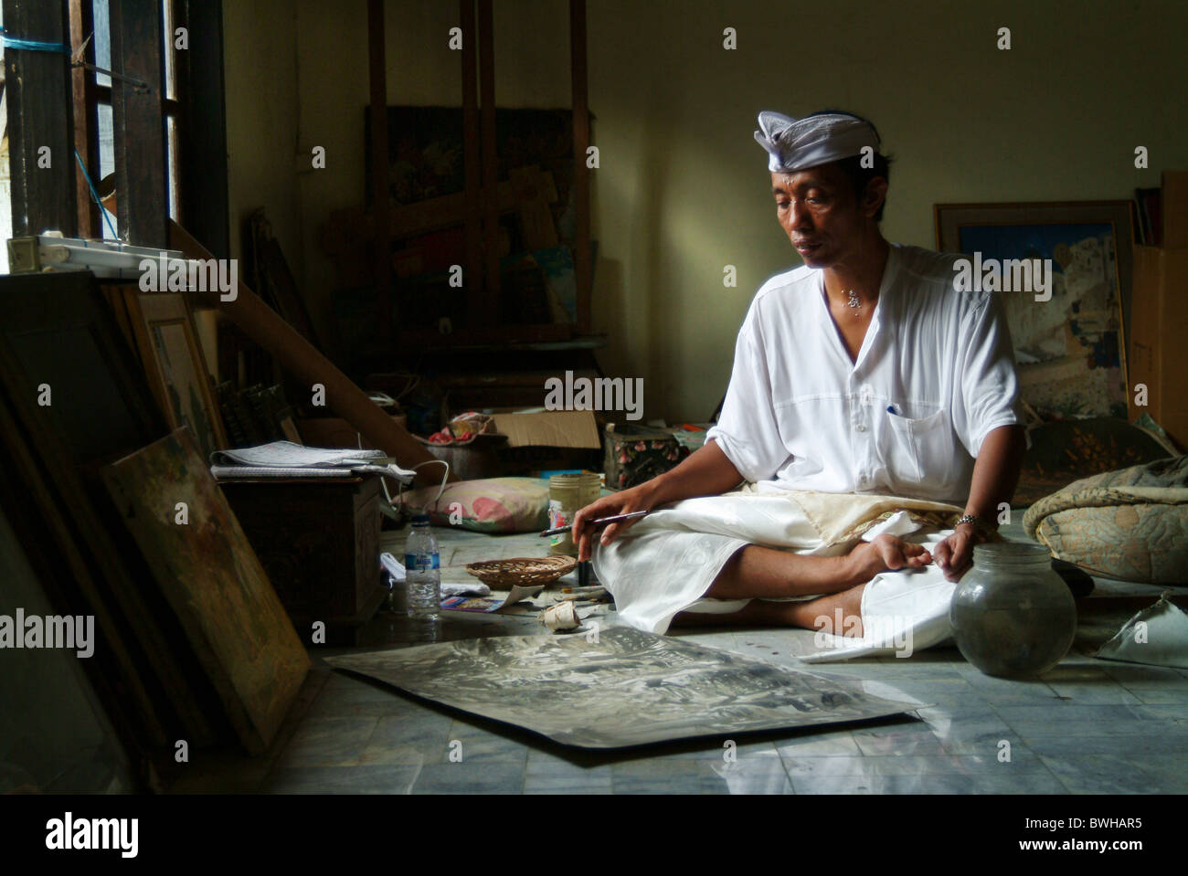An artist paints in his studio in the village of Ubud, Bali, Indonesia ...