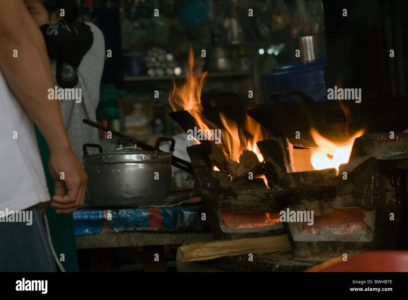 A male cook is making breakfast for food customers on a wood burning ...