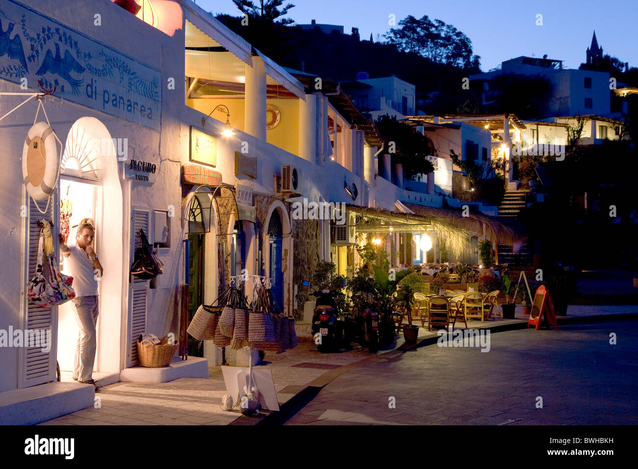 Promenade with shops, restaurants and cafes at night, harbor of Panarea ...