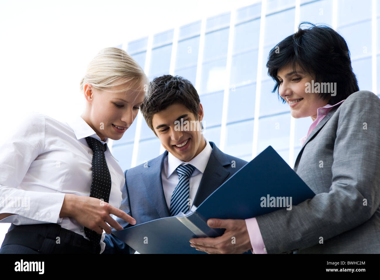 Portrait of busy people discussing new project or working plan outside ...