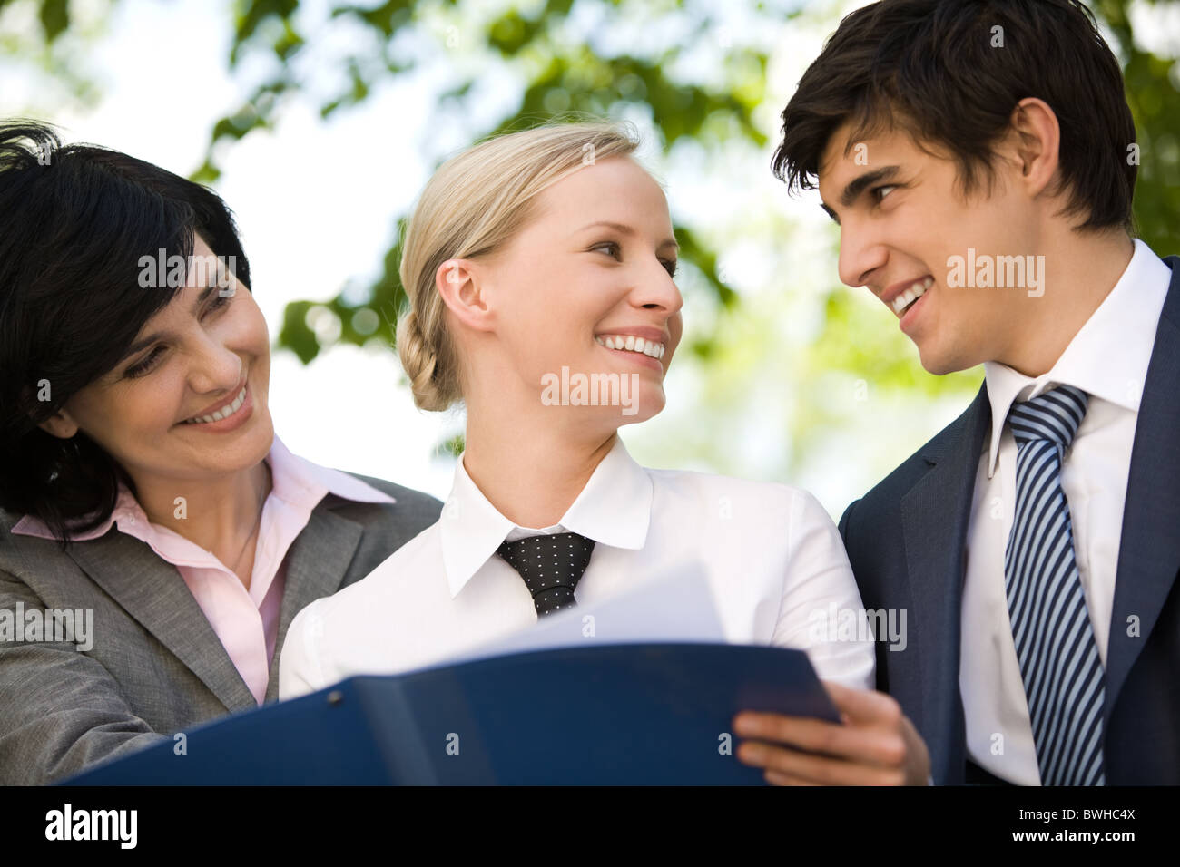 Portrait of happy people discussing new working plan outside at summer ...