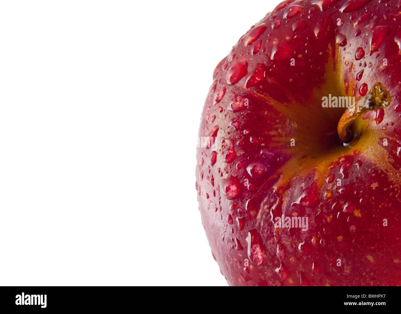 A red apple section cut out against a white background with water spots ...