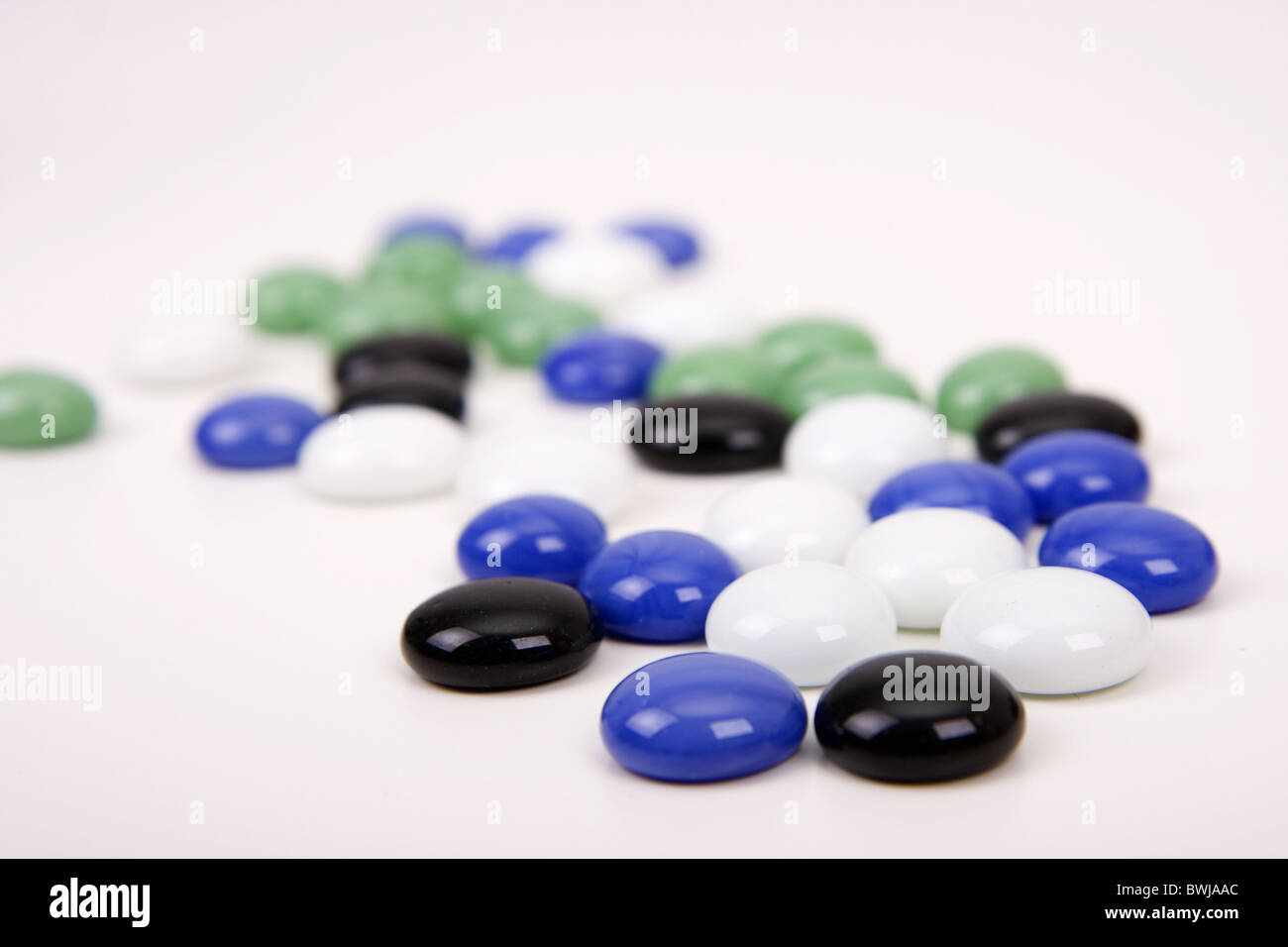 Colour round smooth stones on white table Stock Photo - Alamy