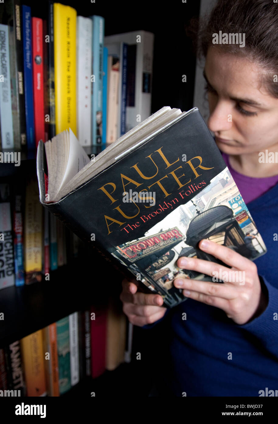 Browsing a book collection in the home, London Stock Photo - Alamy