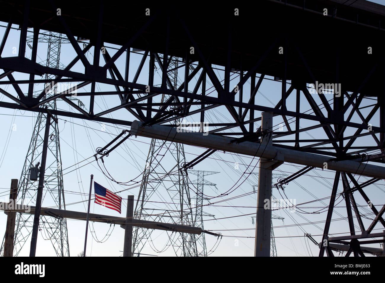 An American flag flies amidst steel girders and electric power lines in ...