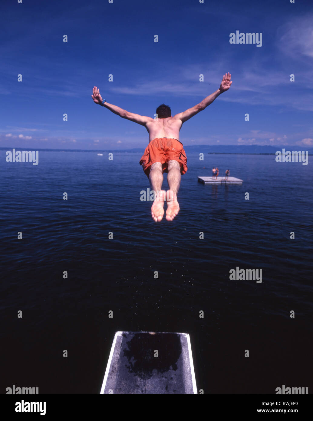 man action jump springboard water lake Lake of Constance bathing summer ...
