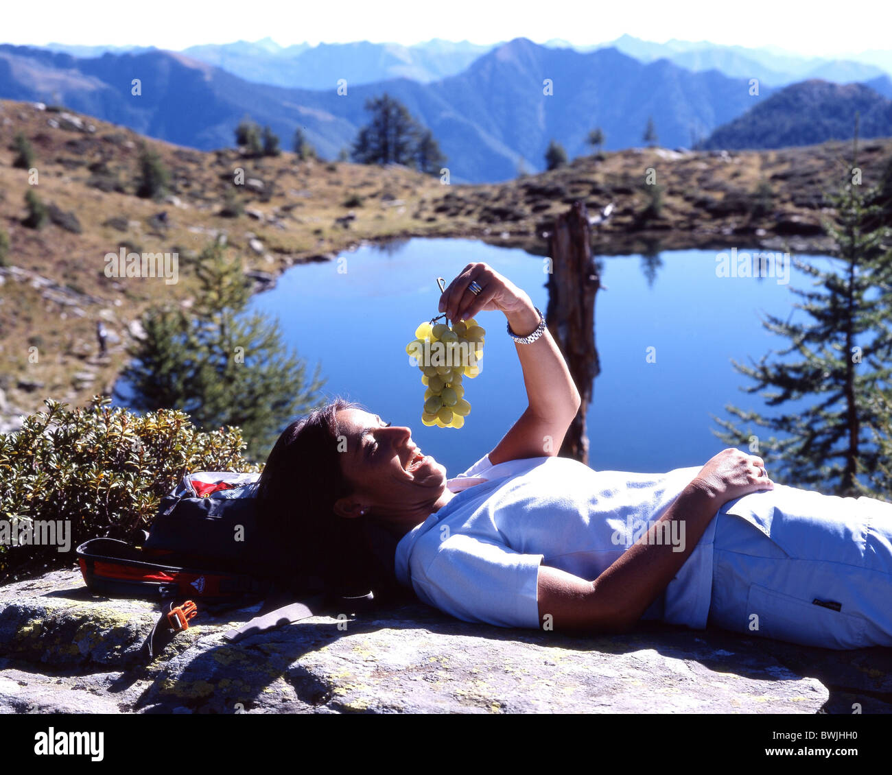 travelers woman relax recumbent lie lying food picnic grapes bunches of ...