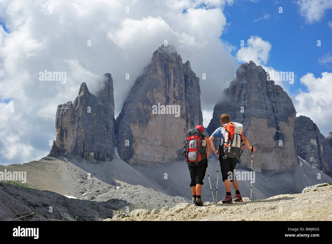 Couple mountain walkers admiring the eroded peaks of the Tre Cime di ...