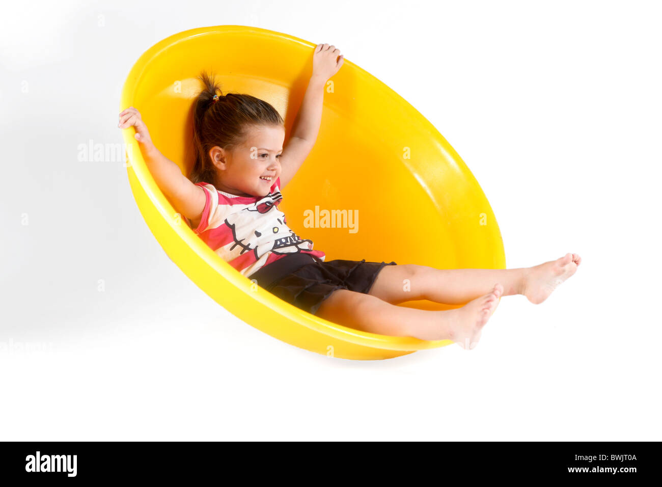 Indoor playground Young girl rolling in a half sphere On white ...
