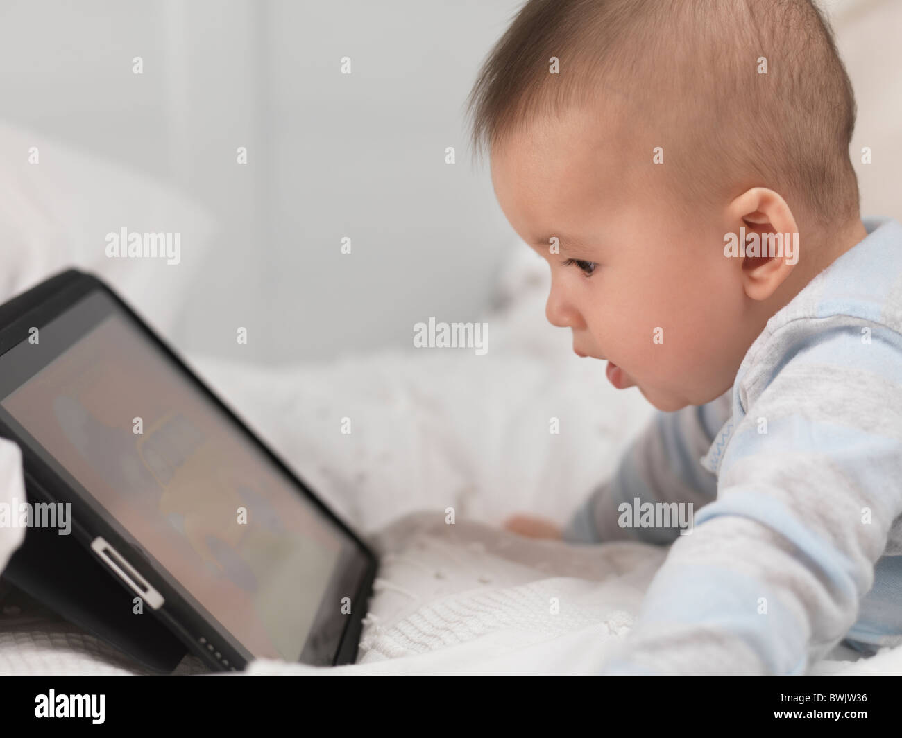 Six month old baby boy playing with Apple iPad tablet computer Stock ...