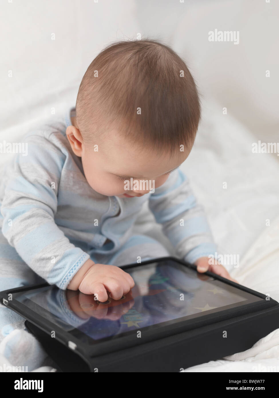 Six month old baby boy playing with Apple iPad tablet computer Stock ...