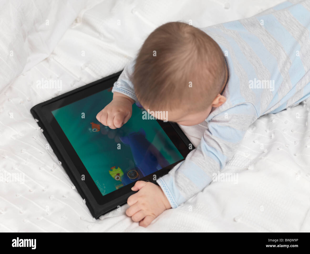 Six month old baby boy playing with Apple iPad tablet computer Stock ...