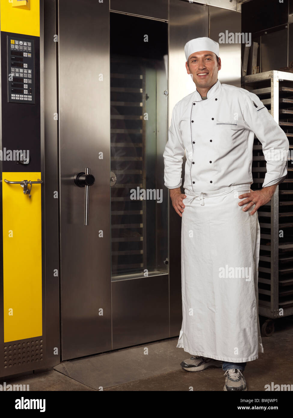 Portrait of a smiling baker standing at a commercial bakery oven Stock ...