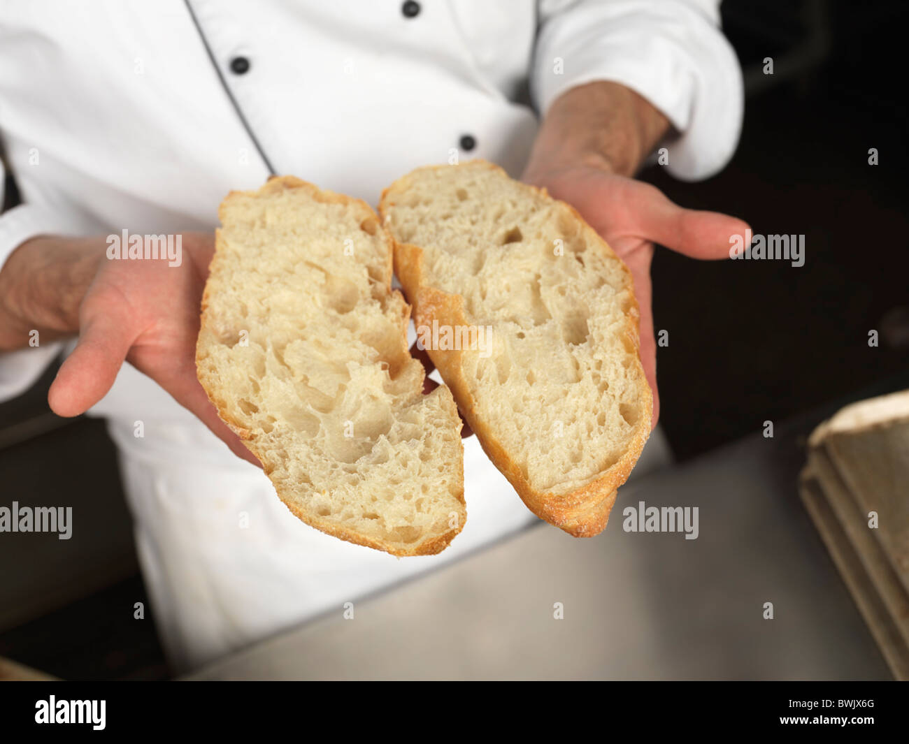 Baker showing a nice porous structure a freshly baked bread sliced in ...