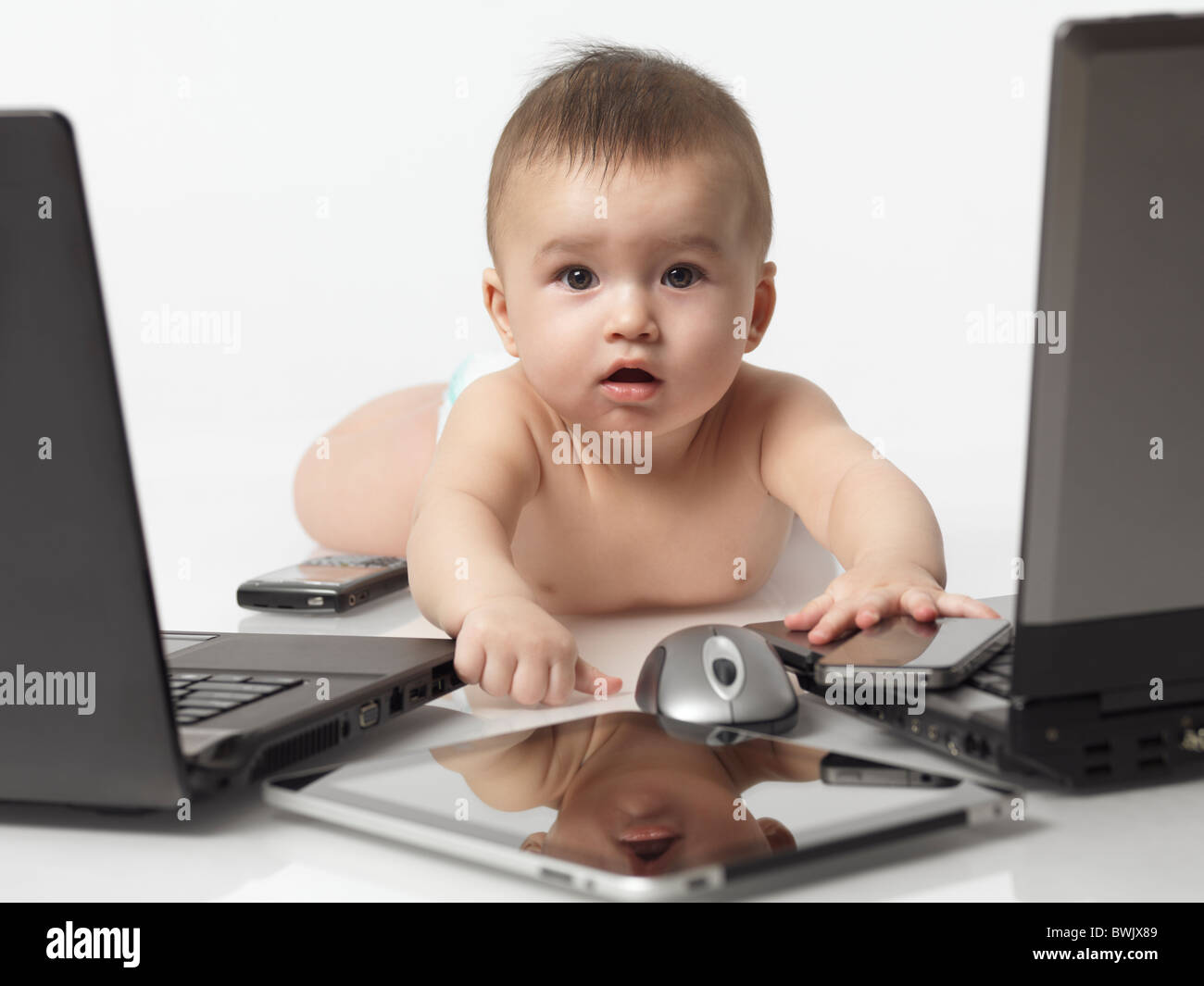 Six month old baby boy busy with computers and cell phones Stock Photo ...