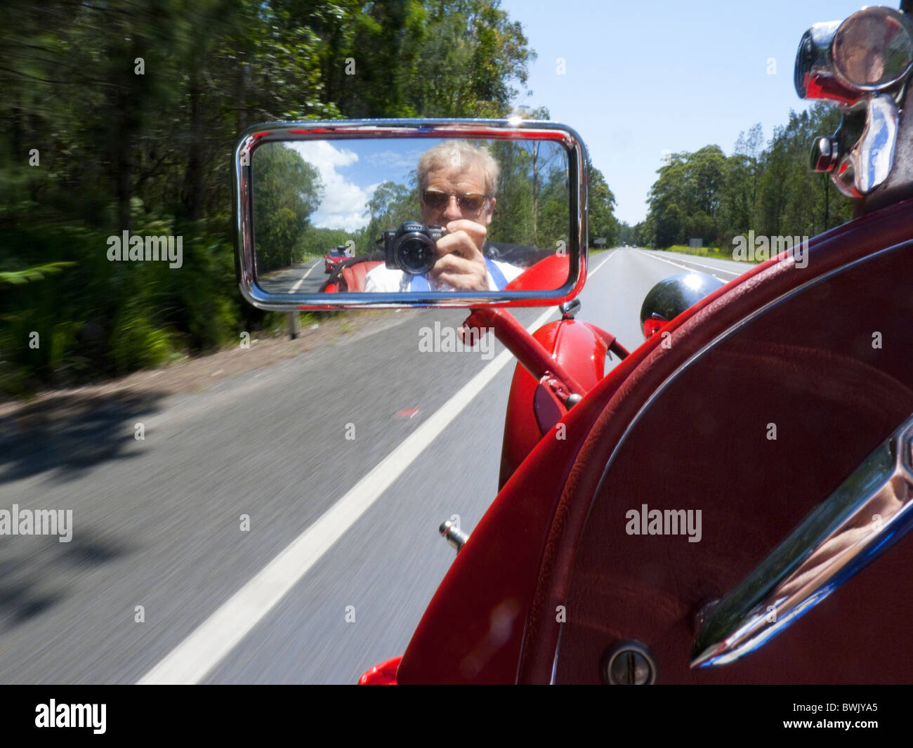 View from open MG sports car of straight road ahead with photographer ...