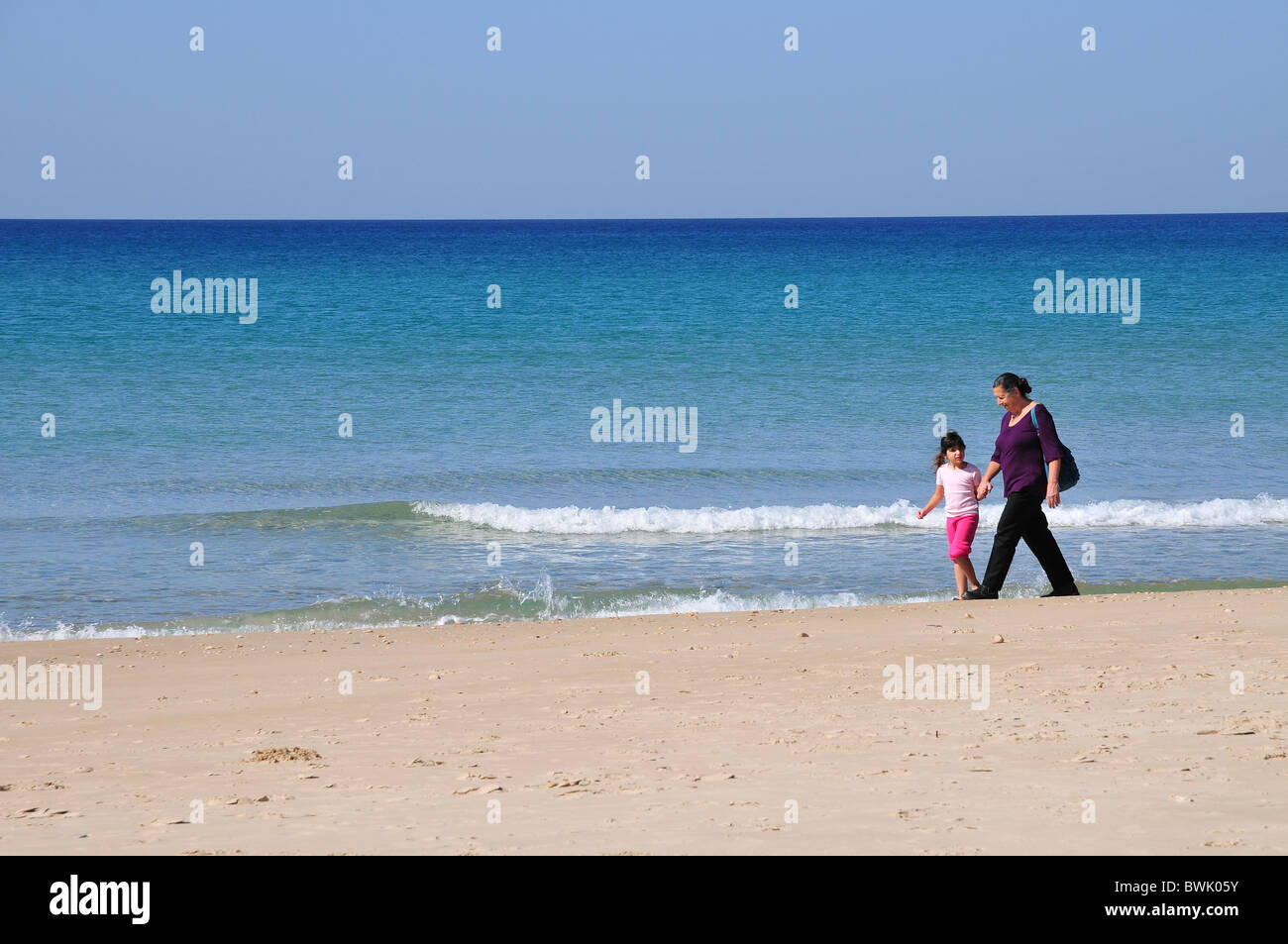 Israel. Haifa, Dado Beach, mother and daughter stroll on the beach ...